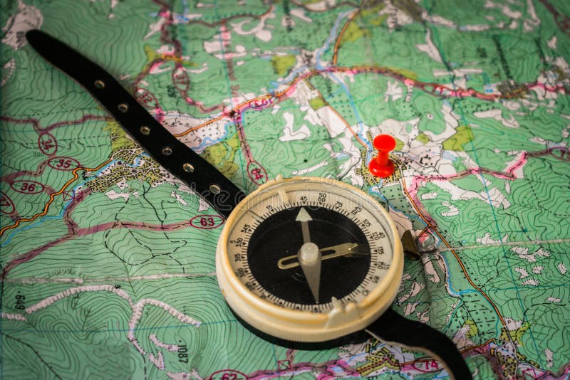 Retro Compass and Drawing Pin are on a Geographic Map. the Background ...