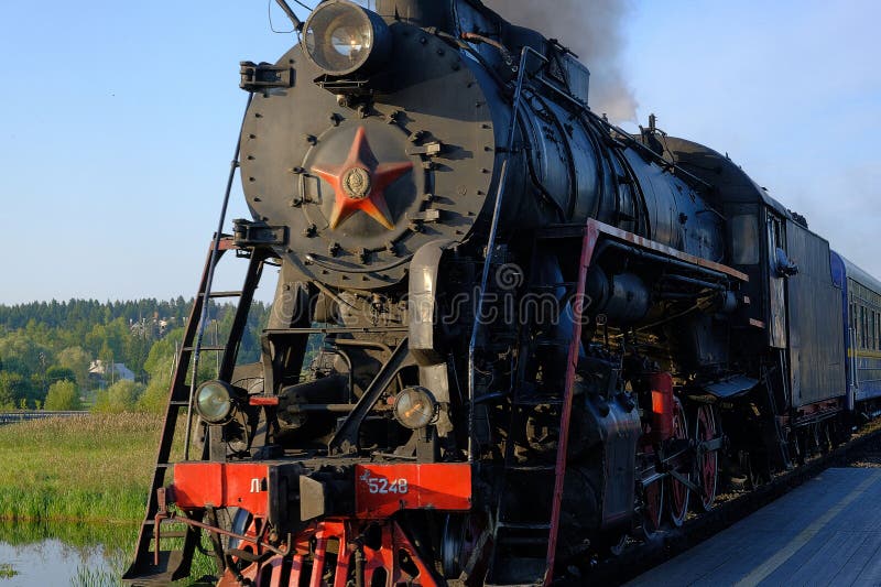 A Retro Locomotive, an Old Train with Carriages, is Moving Along the ...