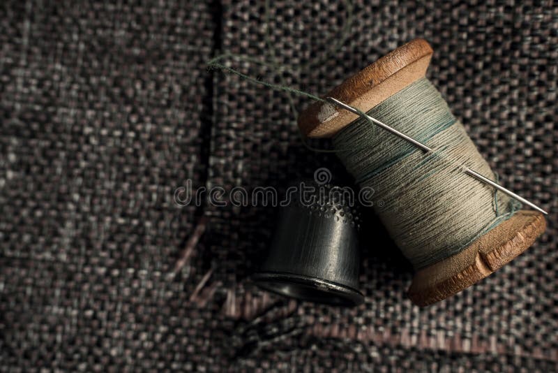 A Retro Needle with Threads and an Old Thimble Lie on a Piece of Cloth ...
