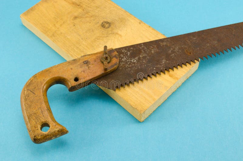 Retro Rusty Hand Saw and Wood Board Part on Blue Stock Photo - Image of ...