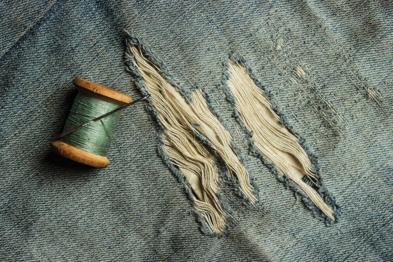 Retro Skein Thread with a Needle on Torn, Rubbed Jeans, Sewing Jeans ...