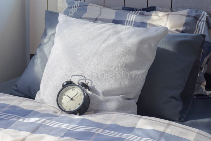 Retro Style Clock on Checked Blanket with White Pillow in Background ...