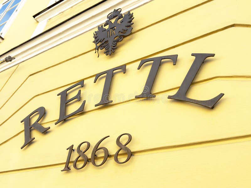 Rettl 1868 Storefront Sign on Yellow Building with Decorative Emblem ...