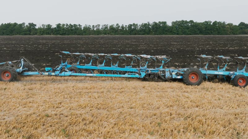 Reversible Plow on Support Wheels Moving Behind a Tractor in an Field ...
