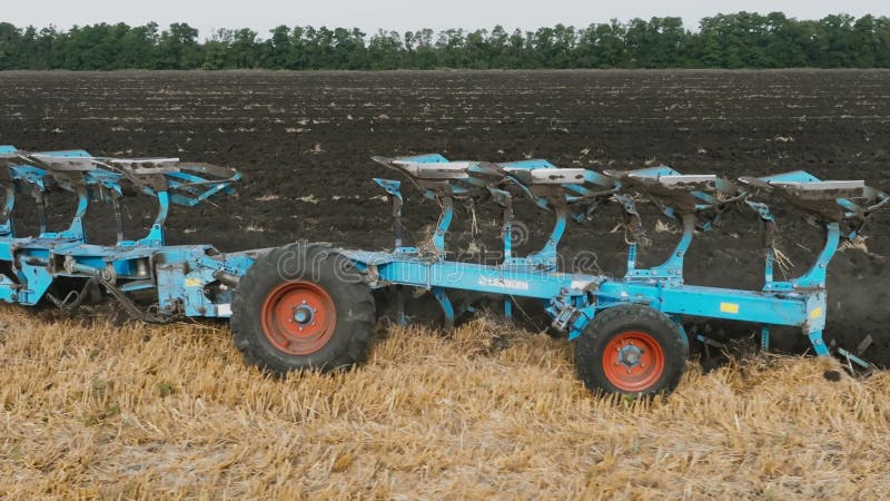 Reversible Plow on Support Wheels Moving Behind a Tractor in an Field ...