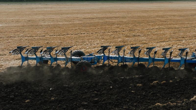 Reversible Plow on Support Wheels Moving Behind a Tractor in an Field ...