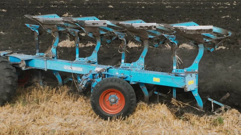 Reversible Plow on Support Wheels Moving Behind a Tractor in an Field ...