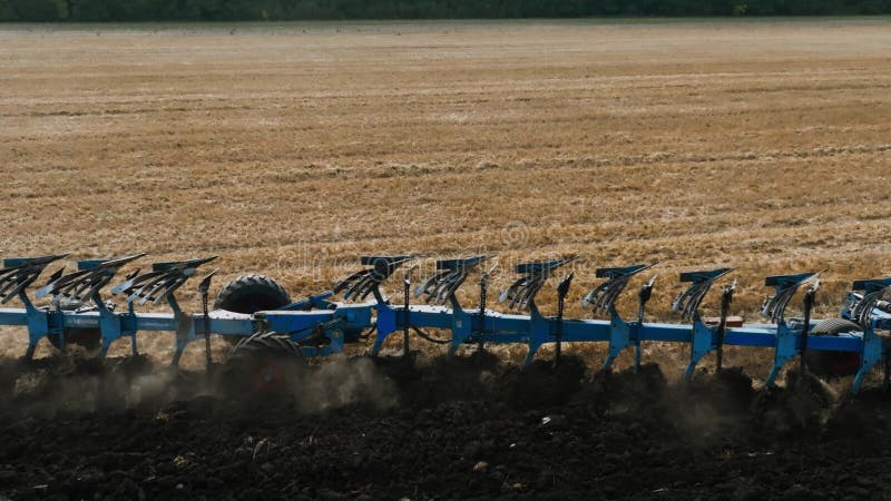 Reversible Plow on Support Wheels Moving Behind a Tractor in an Field ...