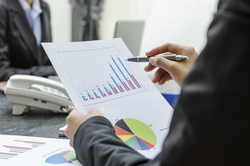 Business Person Writing on Report Chart on Desk in Office Stock Photo ...