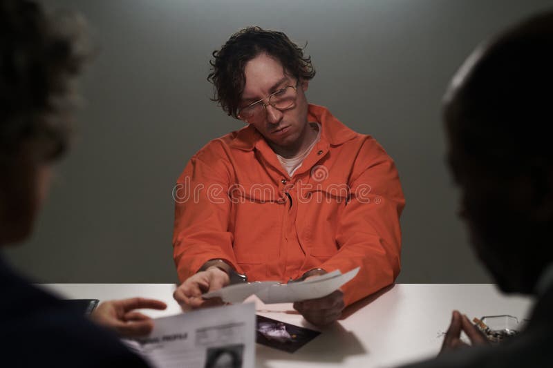 Reviewing Documents in Orange Prison Uniform during Interview Stock ...