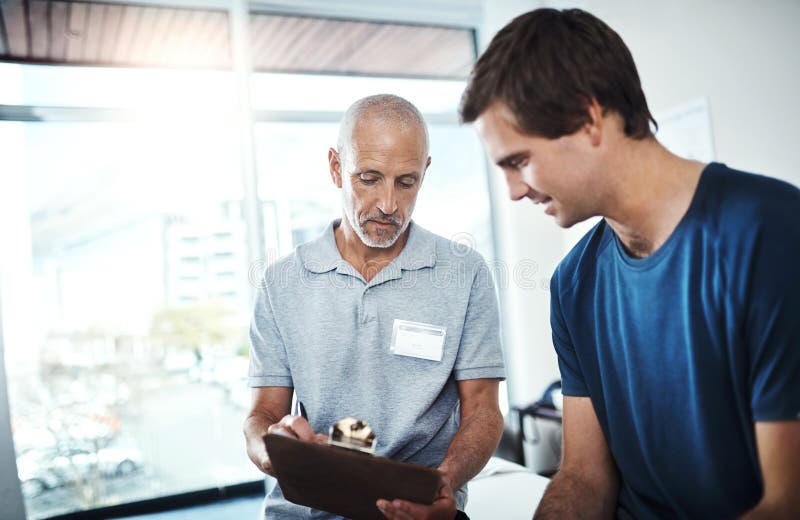 Reviewing Their Treatment Program. a Physiotherapist Having a ...