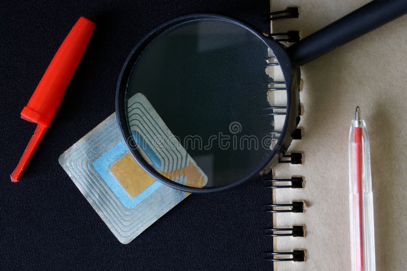 RFID Tag Transponder Under Magnifying Glass, Next To Notepad and Pen ...