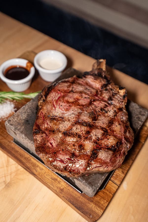 Ribeye Steak with Bone in on Wooden Board Stock Photo - Image of detail ...