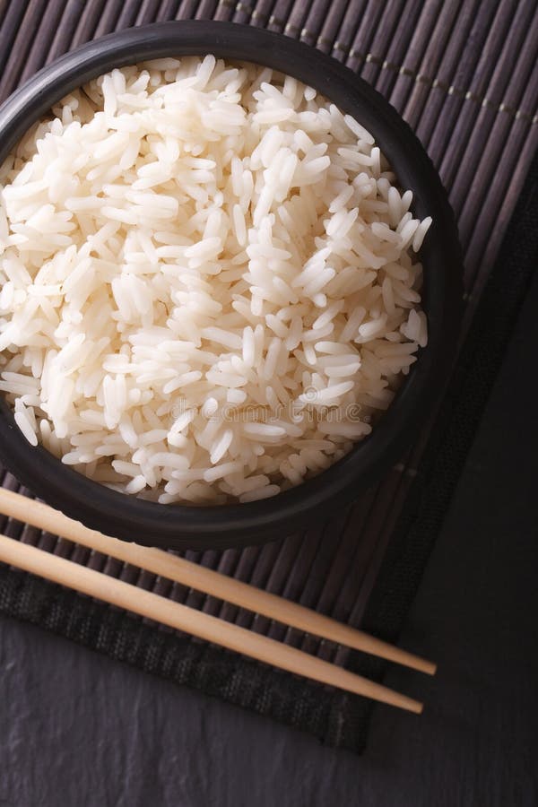 Rice in a Black Bowl Closeup and Chopsticks. Vertical Top View Stock ...