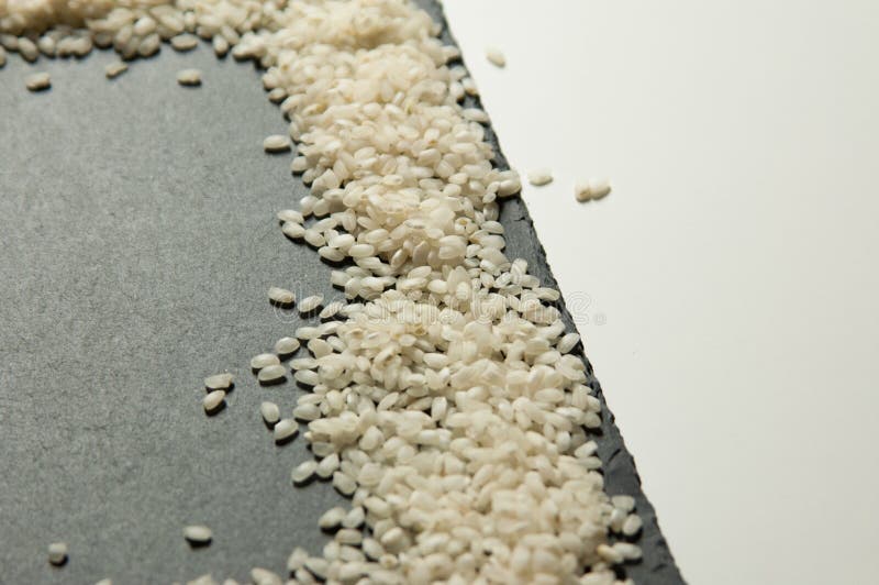 Rice on black slate stone stock photo. Image of nourishment - 187954622