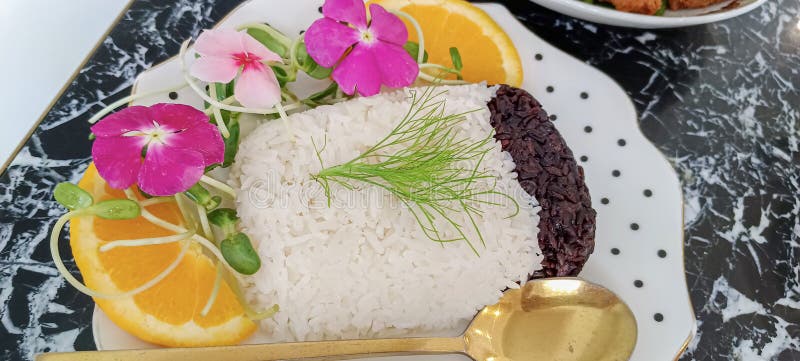 Rice Decorated with Oranges, Edible Flowers, Ready To Be Served Stock ...