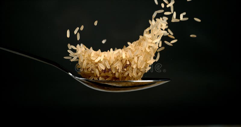 Rice Falling in a Spoon Against Black Background Stock Image - Image of ...