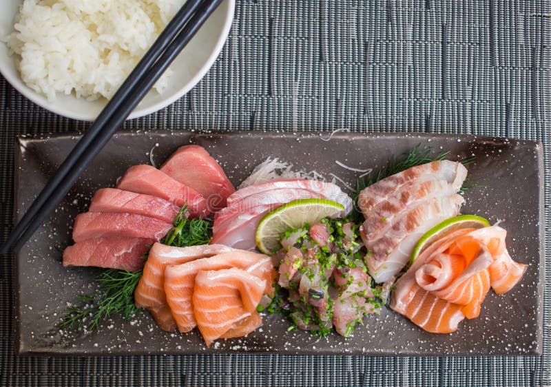 Rice and Japanese Sashimi on a Black Dish Stock Photo - Image of ...
