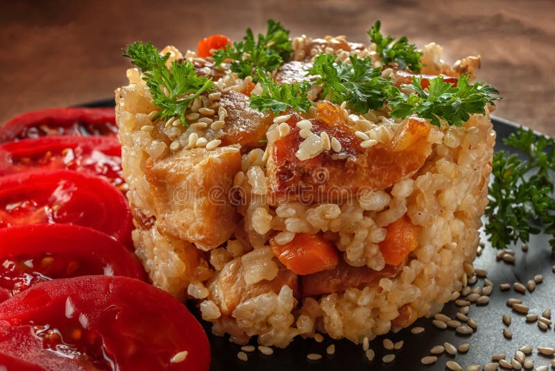 Rice with Meat, Vegetables and Tomatoes in a Plate on the Table Stock ...
