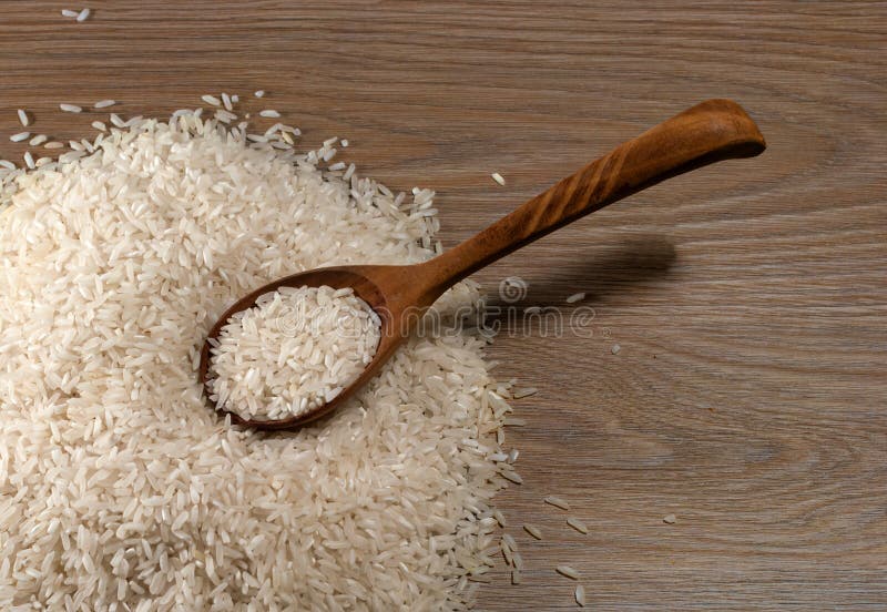 Rice Pour on Wood Panels and a Wooden Spoon. Stock Image - Image of ...