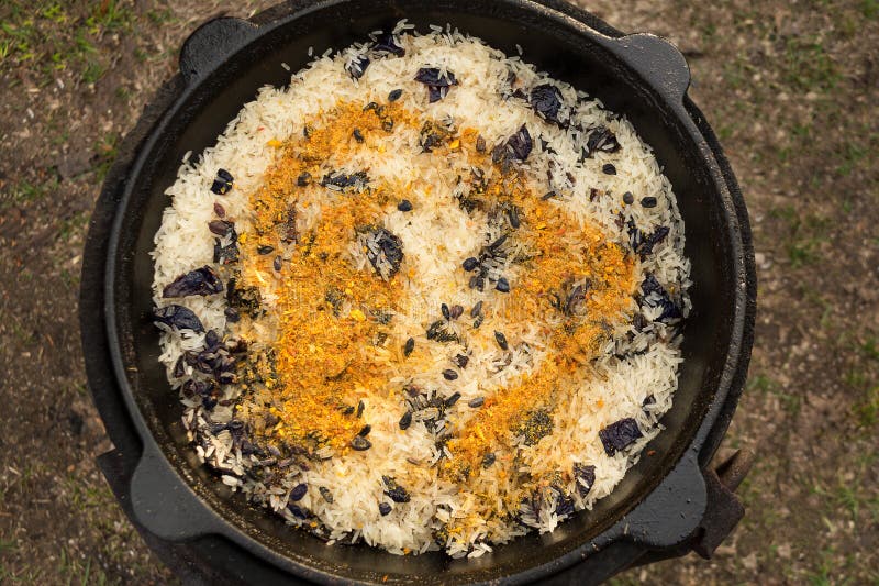 Rice with Prunes, Paprika and Curry in a Cauldron on the Fire. Stock ...