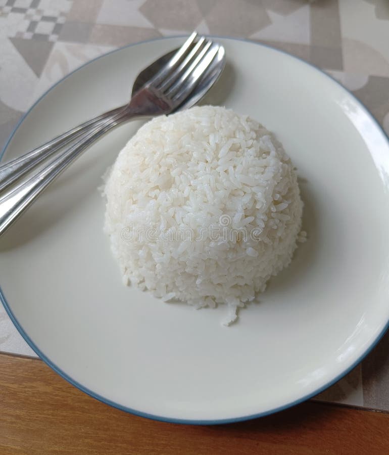 Rice in a White Plate with Spoon and Fork on Table Top View Shoot Stock ...