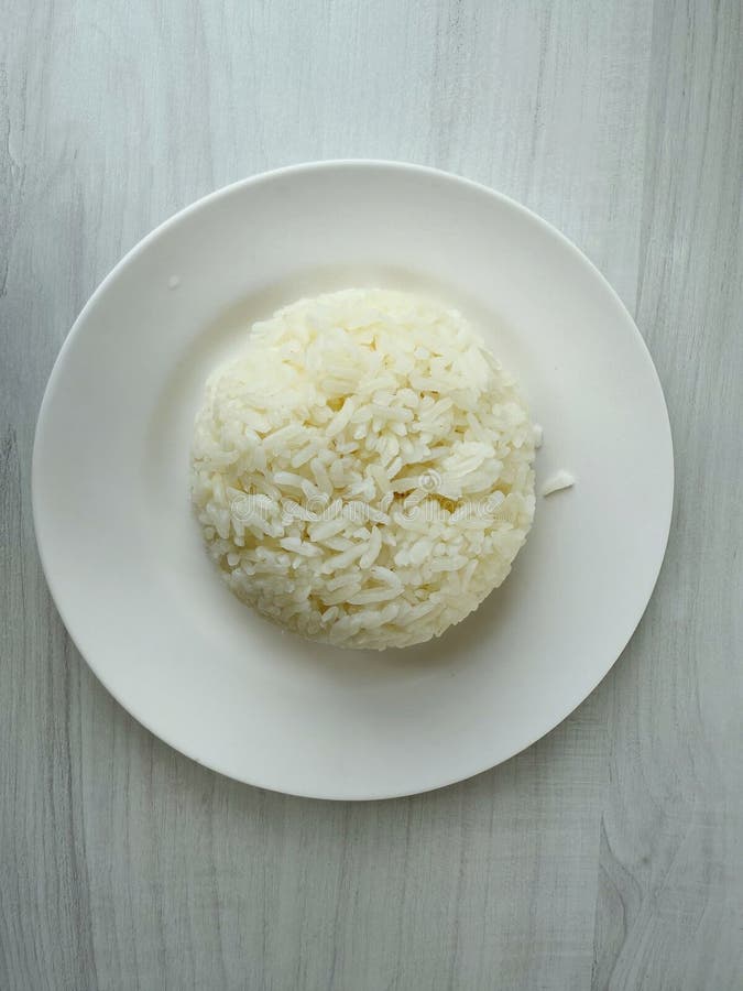 Rice on a White Plate on a Wooden Background. Top View. Stock Photo ...