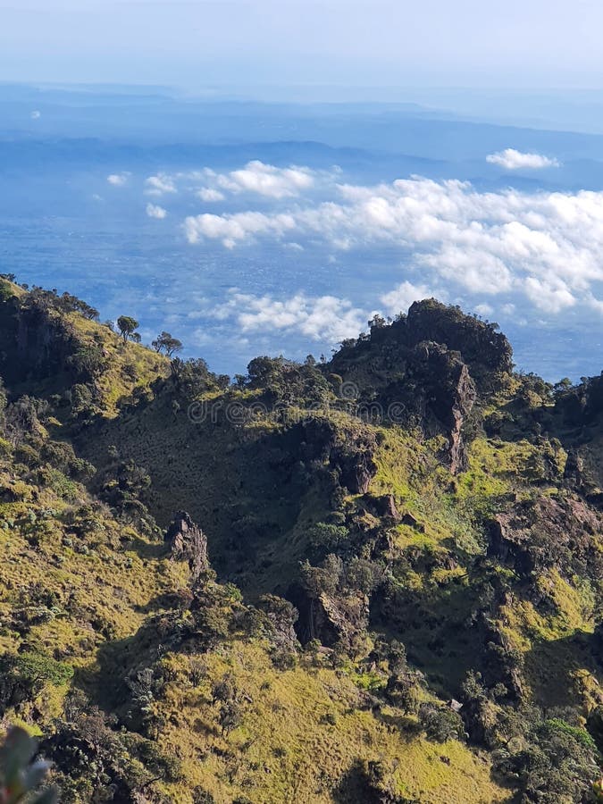 A Ridge of Cleft Mountain Peaks Filled with Green Vegetation and Rocks ...
