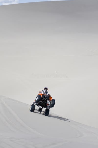 Riding ATV in sand dunes stock image. Image of angle - 17256419