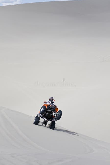 Riding ATV in sand dunes stock image. Image of angle - 17256419