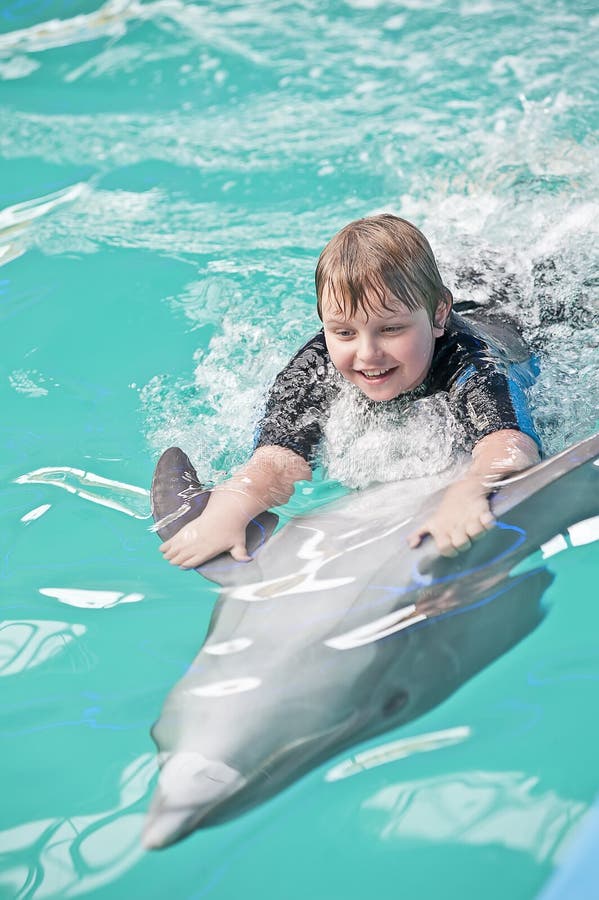 Riding on a dolphin 2 stock photo. Image of blue, attractive - 34307652
