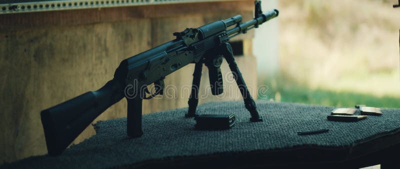Rifle Resting on Bipod on Mat at Shooting Range with Ammunition beside ...