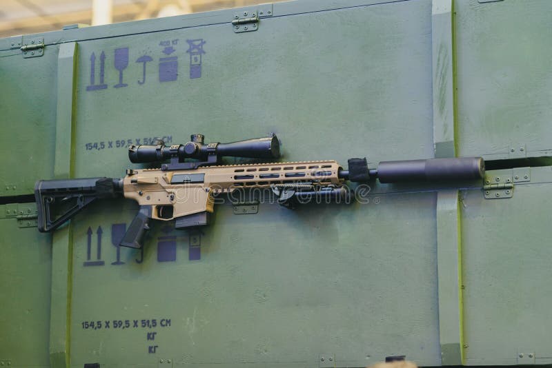 A Rifle with a Silencer and a Telescopic Sight Hangs on a Box from ...