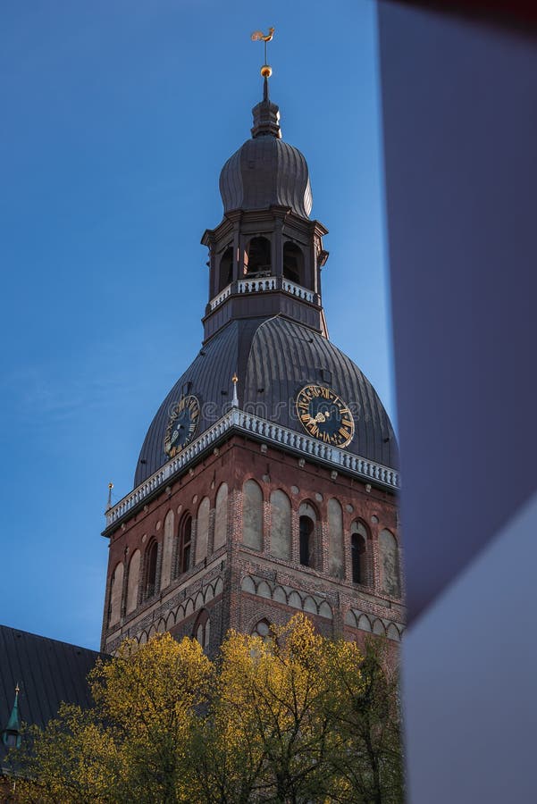 Riga Cathedral with Dark Dome and Clock Tower Under Blue Sky Stock ...