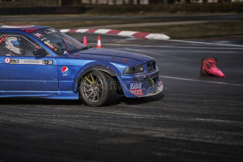 12-05-2022 Riga, Latvia a Blue Car is Driving Around a Track with a Red ...