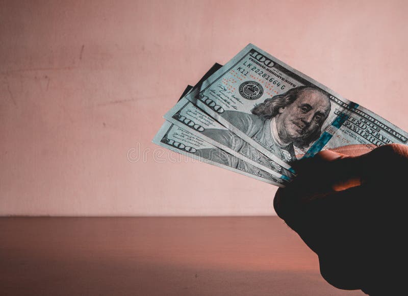 Right Hand Holds Stack of 100 Dollars Banknotes on Black Background ... Right Hand Holds Stack of 100 Dollars Banknotes on Black Background ...