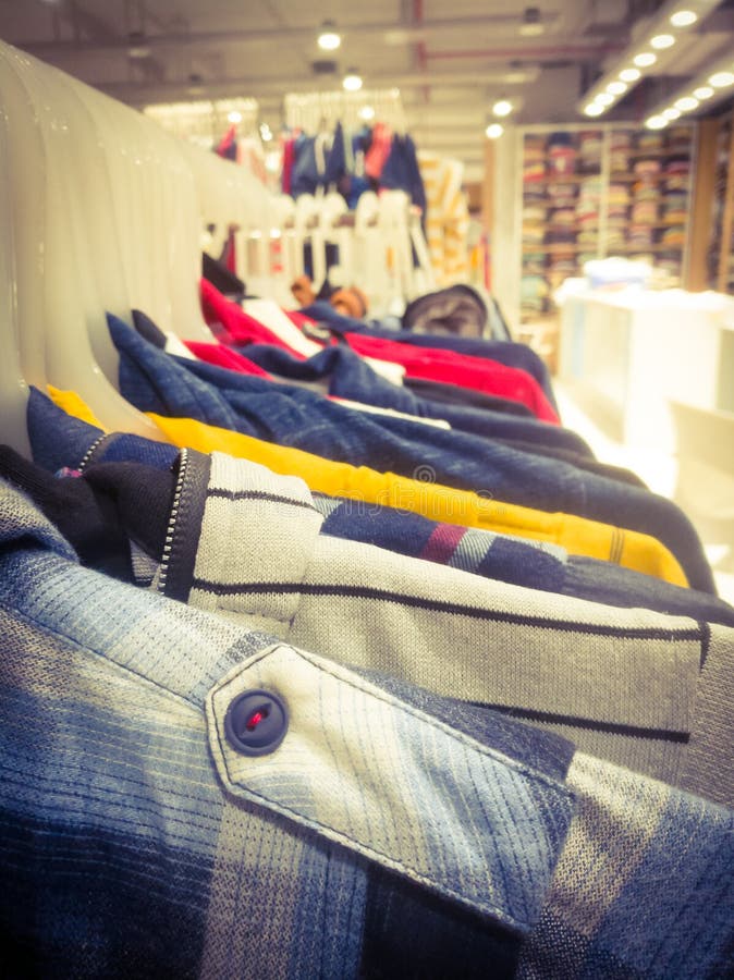 Right Side View of an Array of Shirts Hanging in a Bar Inside Textile ...