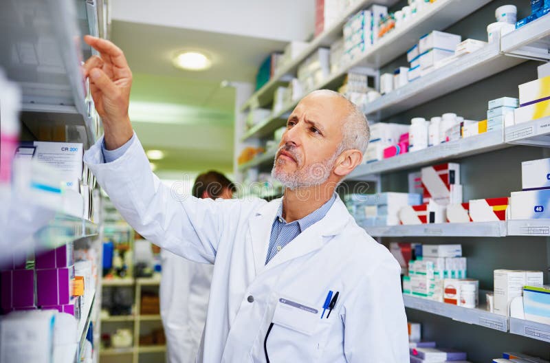The Right Treatment is His Priority. a Mature Pharmacist Doing ...