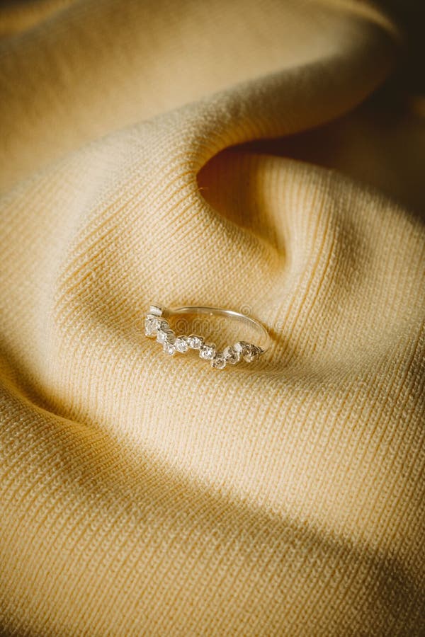 Ring Atop a Beige Fabric Surface Illuminated by a Warm Light Stock ...