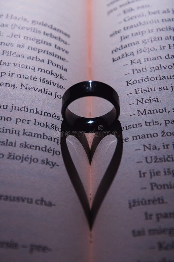 Ring Casts a Heart Shadow Over a Book Page with Pages Stock Photo ...