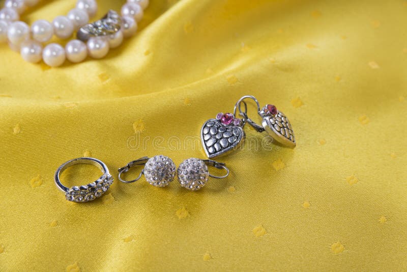 Ring and Two Pairs of Earings on the Yellow Stock Photo - Image of ...