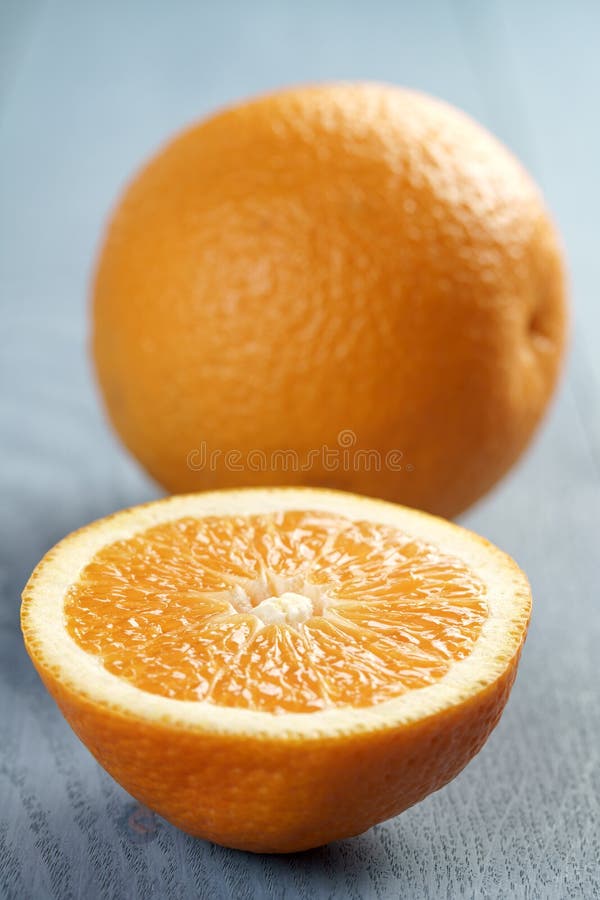 Ripe Oranges with Half Sliced on Blue Wood Table Stock Photo - Image of ...