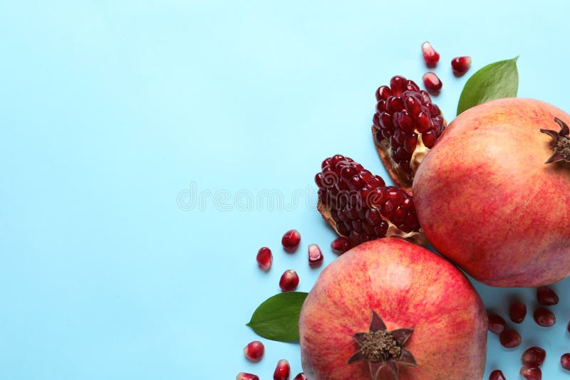 Ripe Pomegranates and Leaves on Color Background, Top View Stock Photo ...