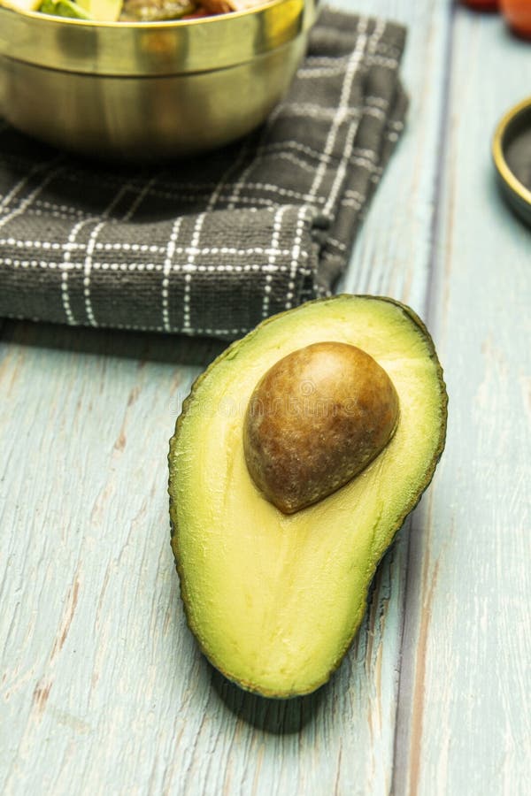 A Ripe Super Avocado Cut in Half on a Light Blue Table Stock Photo ...
