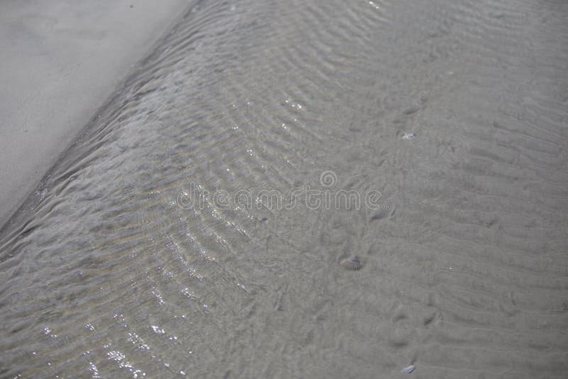 Rippled Water Rolling on the Sandy Beach with Silver Sunlight ...