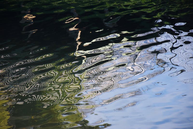 Ripples on a River Reflect the Sky and Buildings Artistically Stock ...