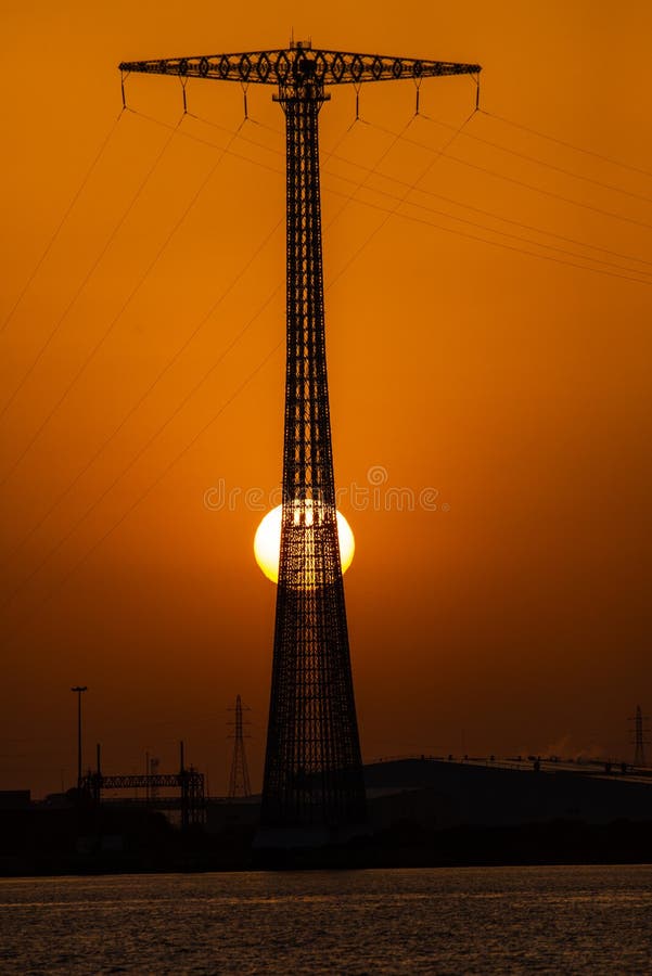 Rising sun behind pylon stock photo. Image of nature - 323307174