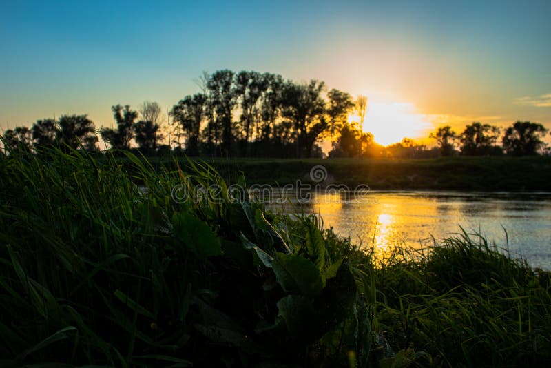 River bank at sunset stock image. Image of sunset, reflections - 265244619