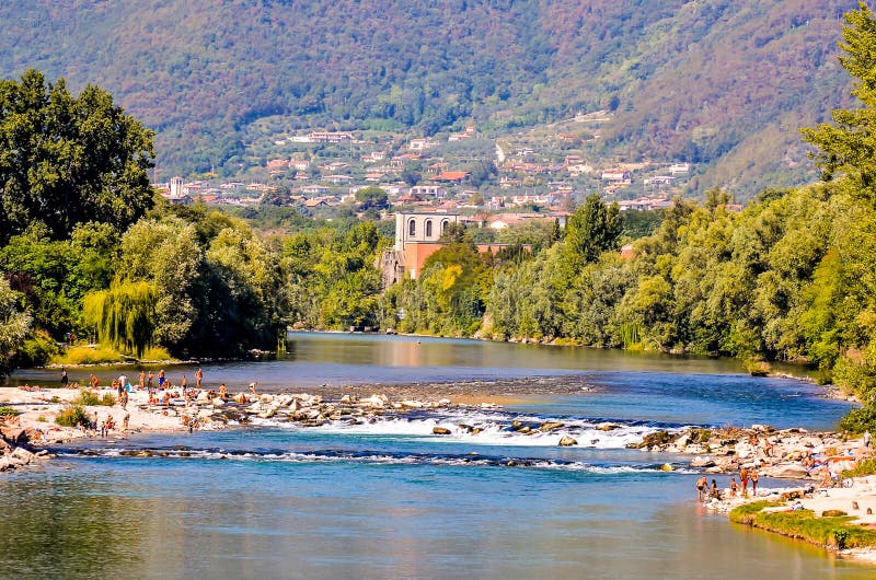 A River with a Bridge Over it and People on the Bank Stock Photo ...