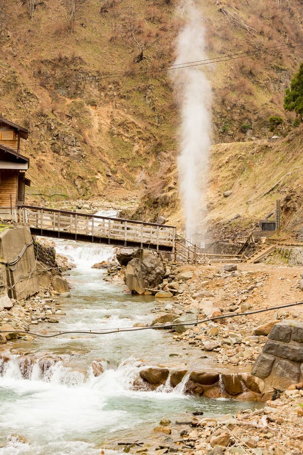 River Flowing at the Foot of a Mountain and a Small Foot Bridge Stock ...